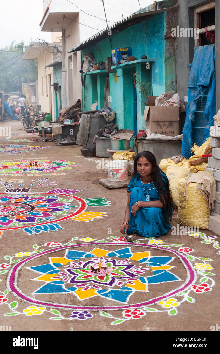 Indian woman making a Rangoli design in an Indian street during the ...
