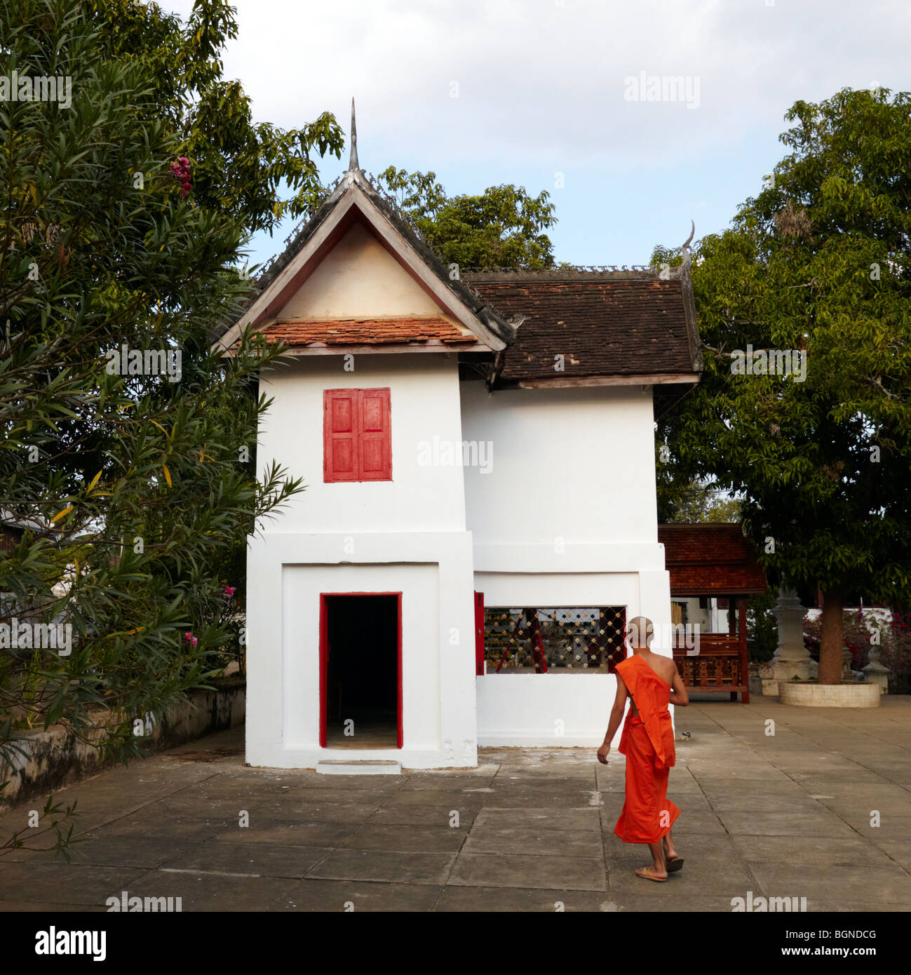 Buddhist monk walking toward a French building in Luang Prabang, Laos ...