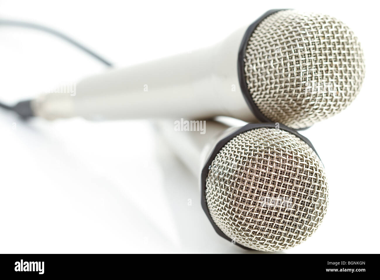 Two microphones on reflecting white background Stock Photo - Alamy