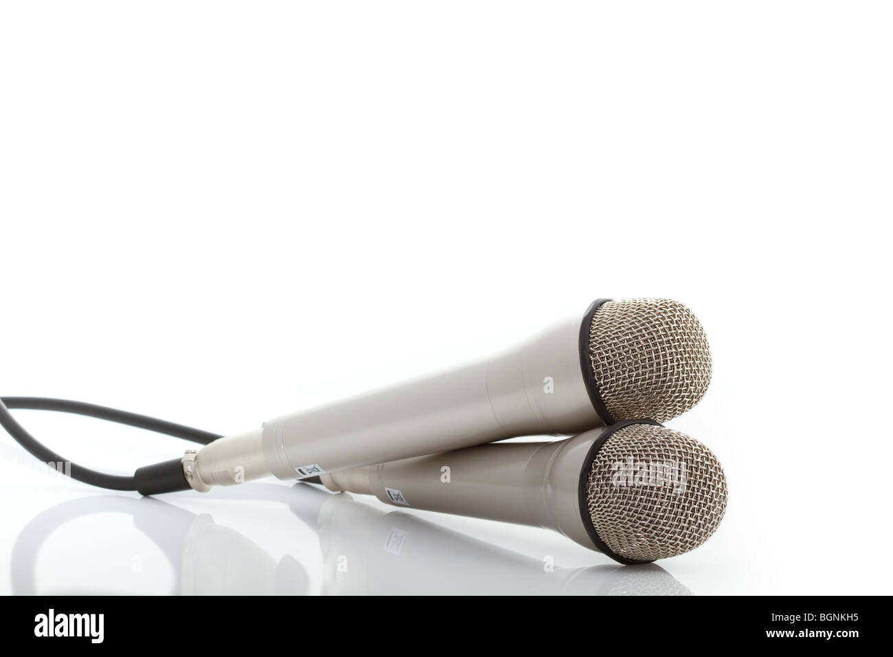 Two microphones on reflecting white background Stock Photo - Alamy