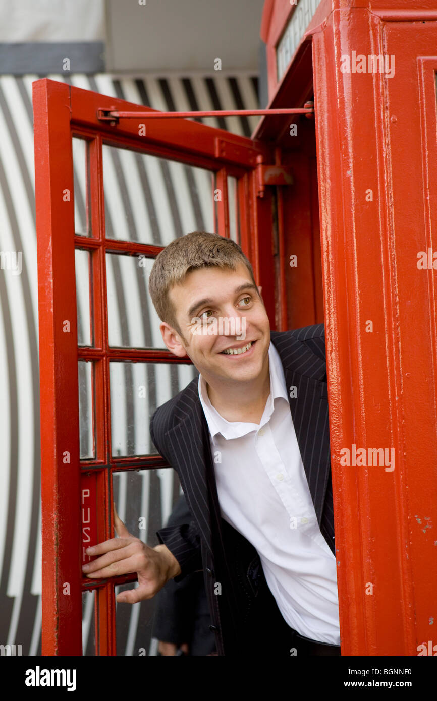man inside traditional English red telephone box Stock Photo - Alamy