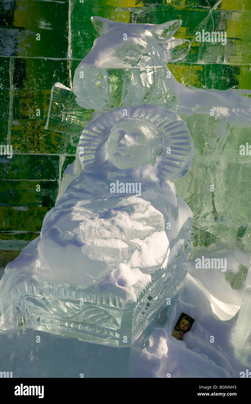 Icy sculpture. Jesus, Mary and Joseph at the manger. Snow`s street near ...