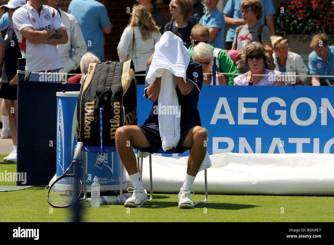 A tennis players wipes his face with a towel during the Aegon ...