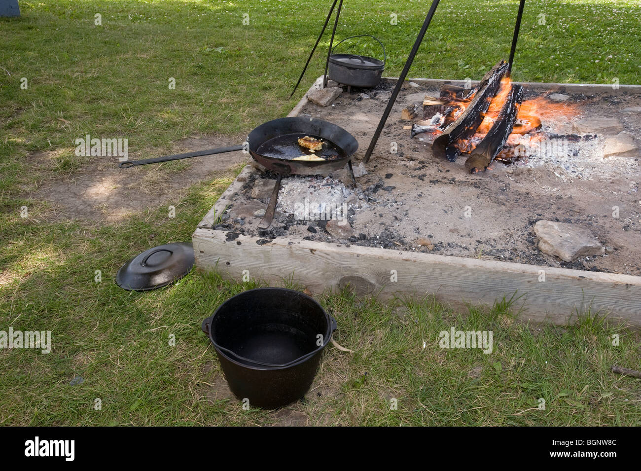 Spider pan, three-legged frying pan over hot coals, being used to ...