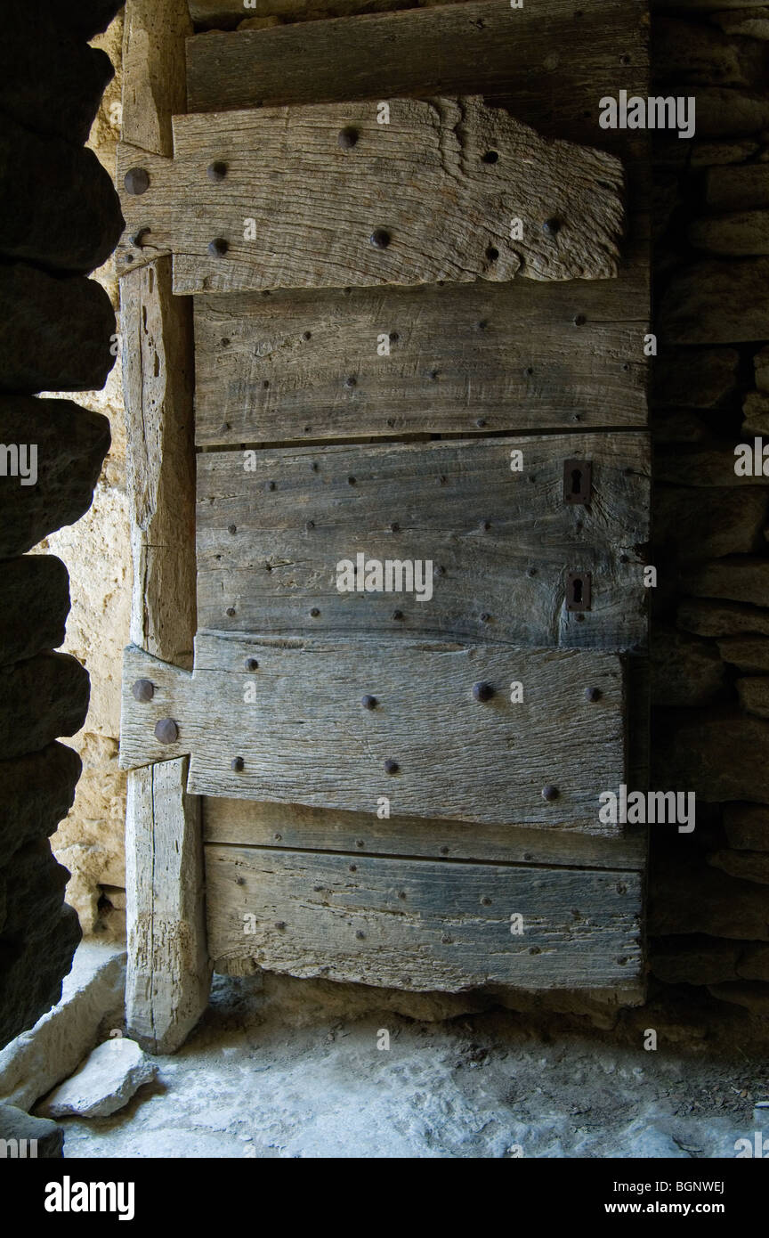 Old wooden door in restored village Les Bories with traditional stone ...
