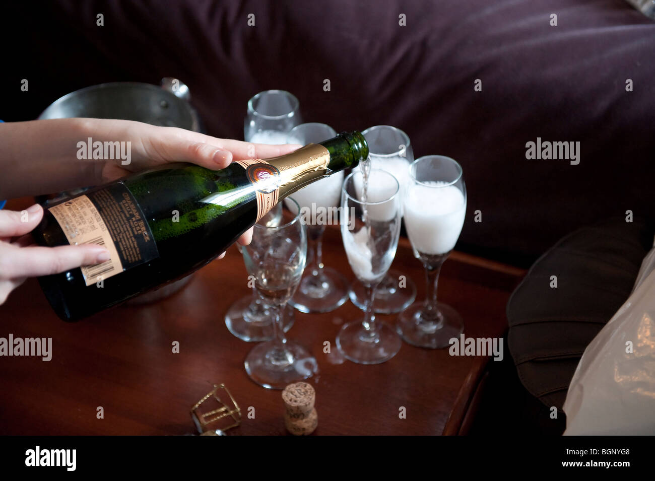 Hands pouring champagne for the bride and bridesmaids whilst getting ...