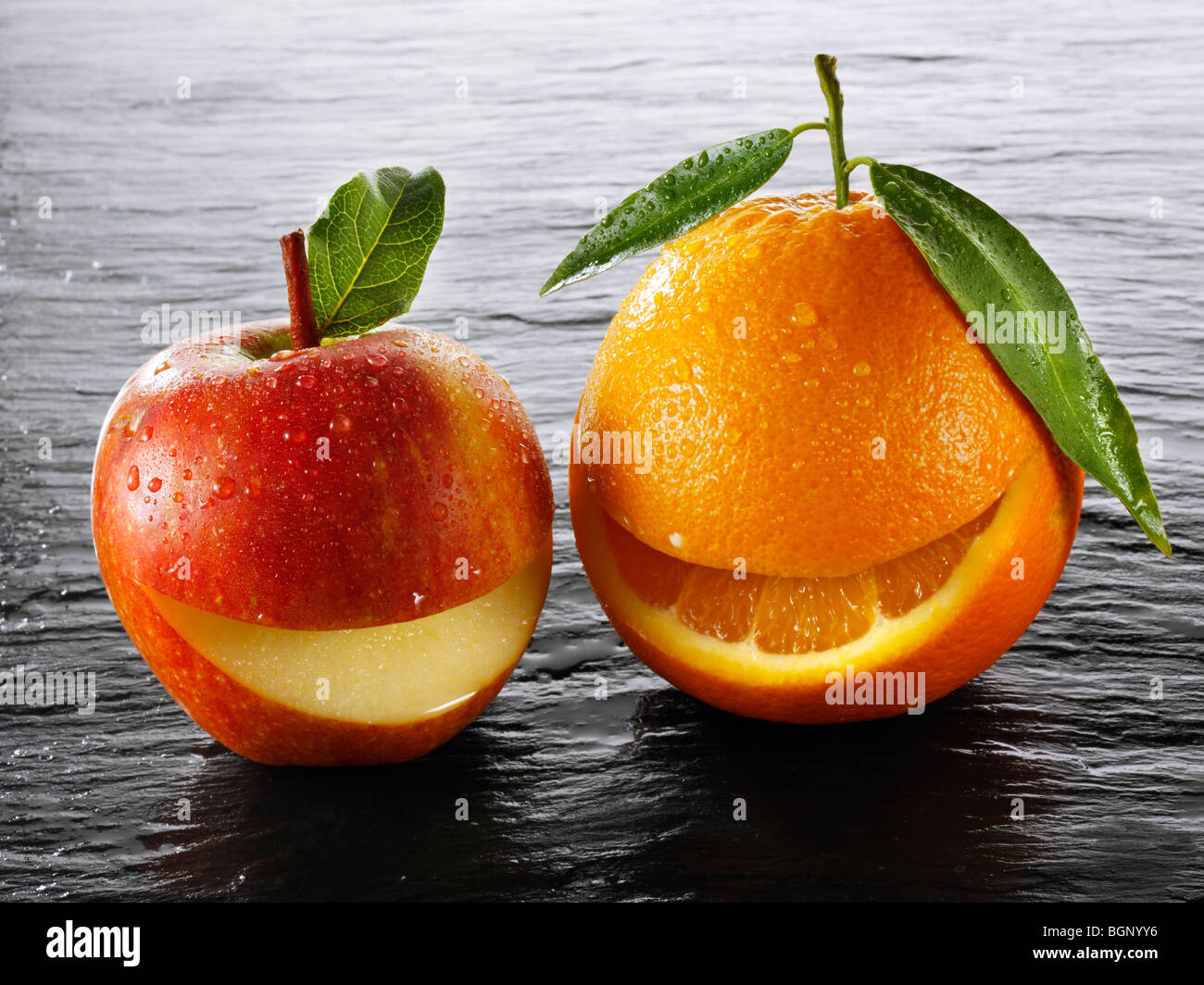 Smiley orange and apple on a black background Stock Photo - Alamy