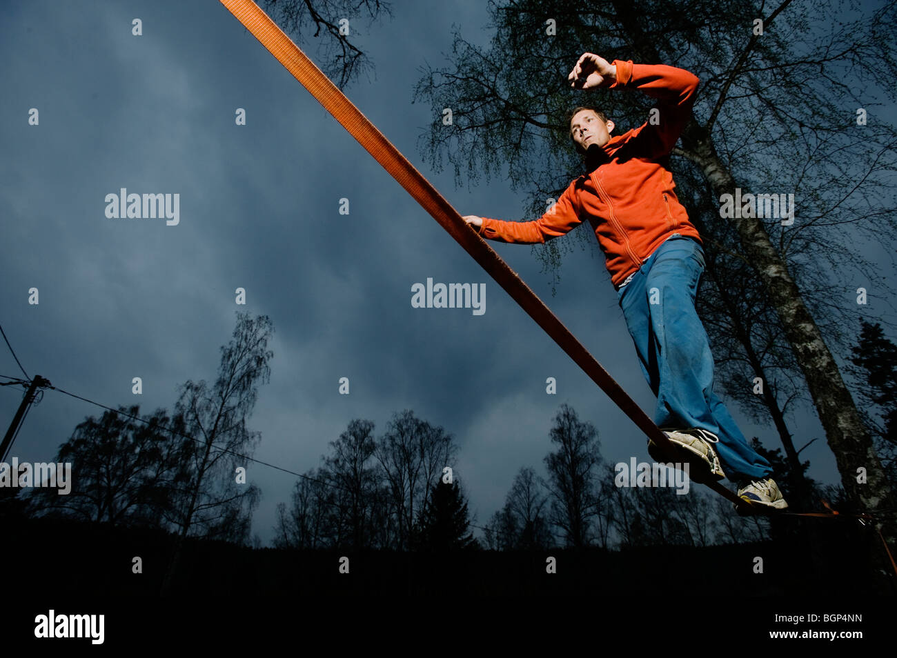 A man balancing on a cord Stock Photo - Alamy