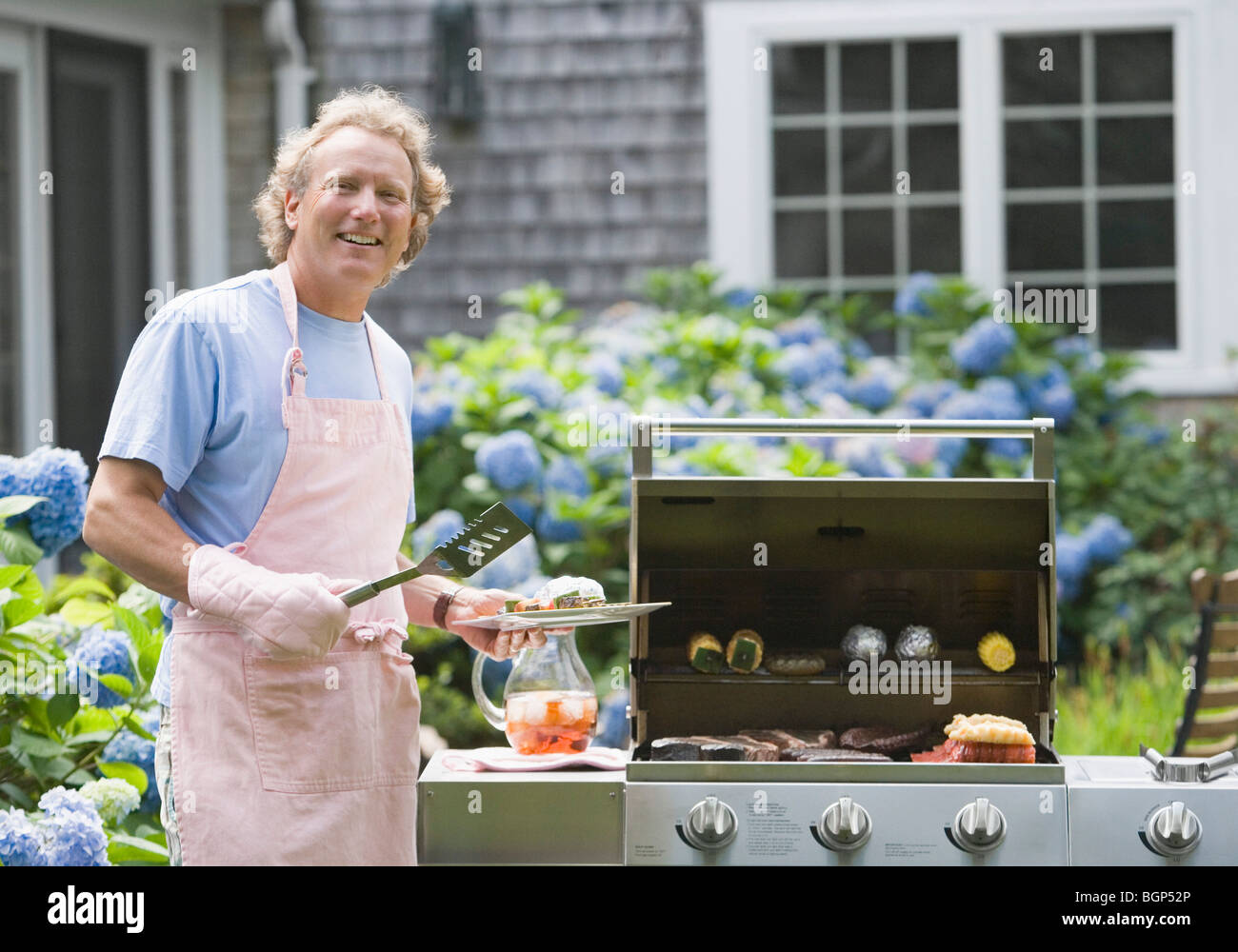 Portrait of a mature man cooking food on a barbecue grill Stock Photo ...