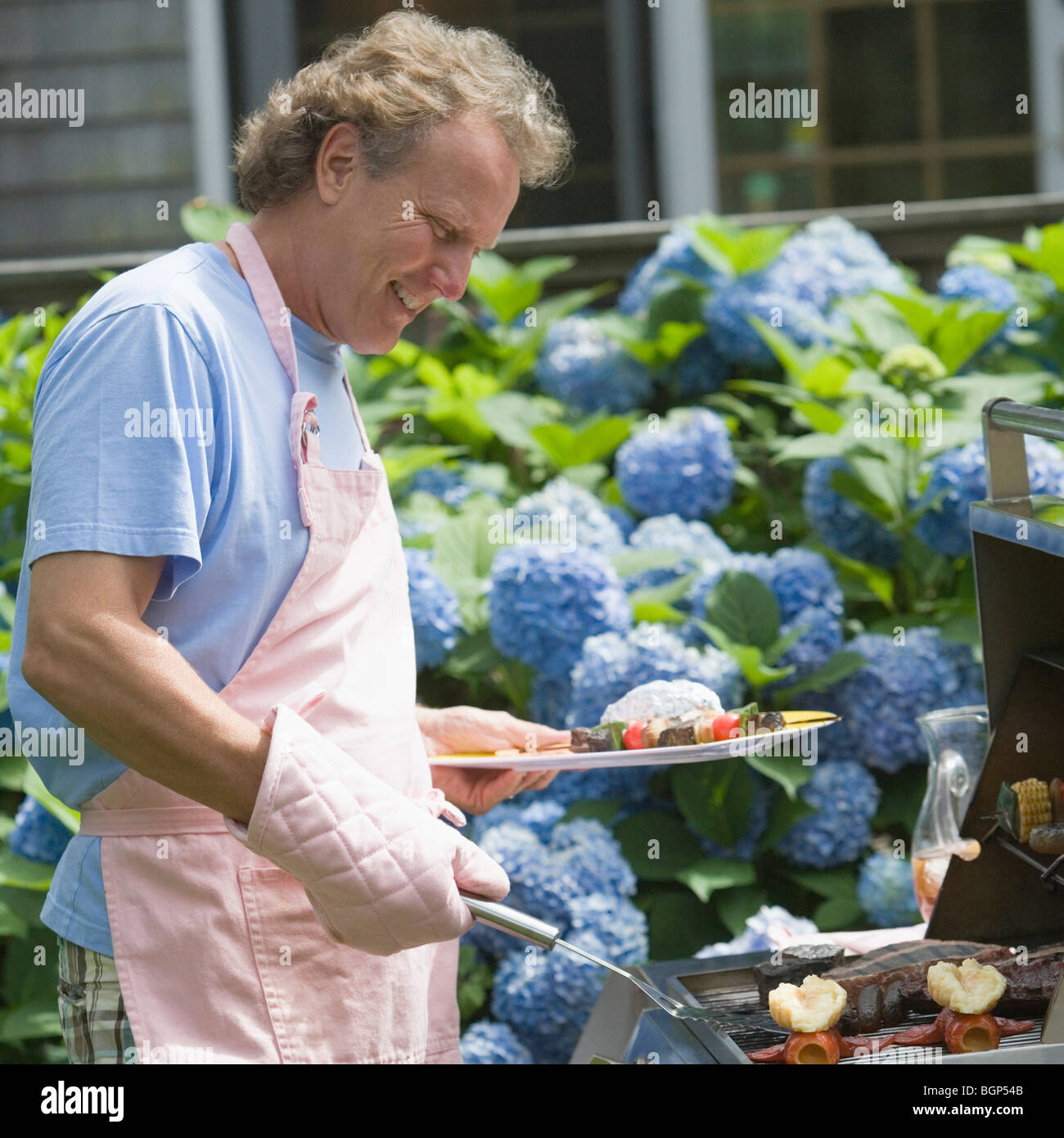 Side profile of a mature man cooking food on a barbecue grill Stock ...