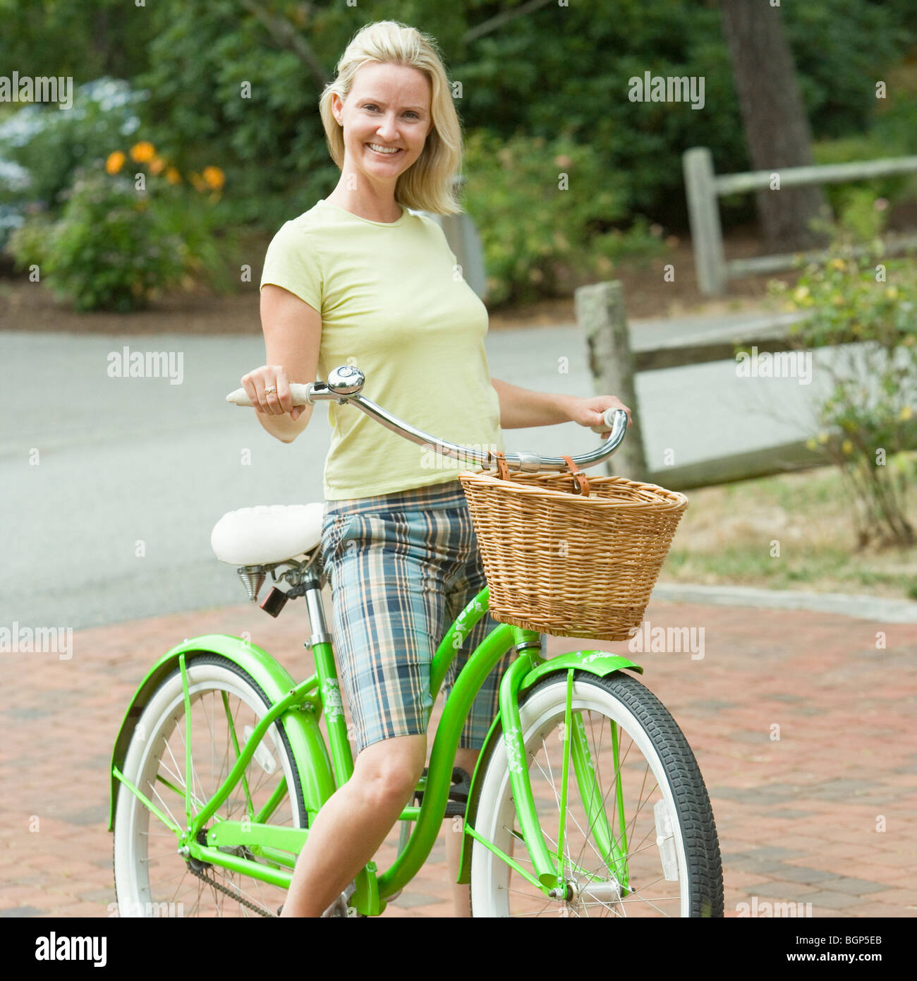 Portrait of a mid adult woman on a bicycle and smiling Stock Photo - Alamy