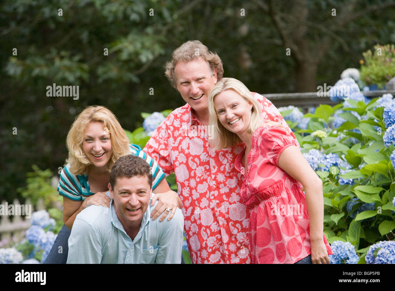 Portrait of two couples standing together and smiling in a park Stock ...