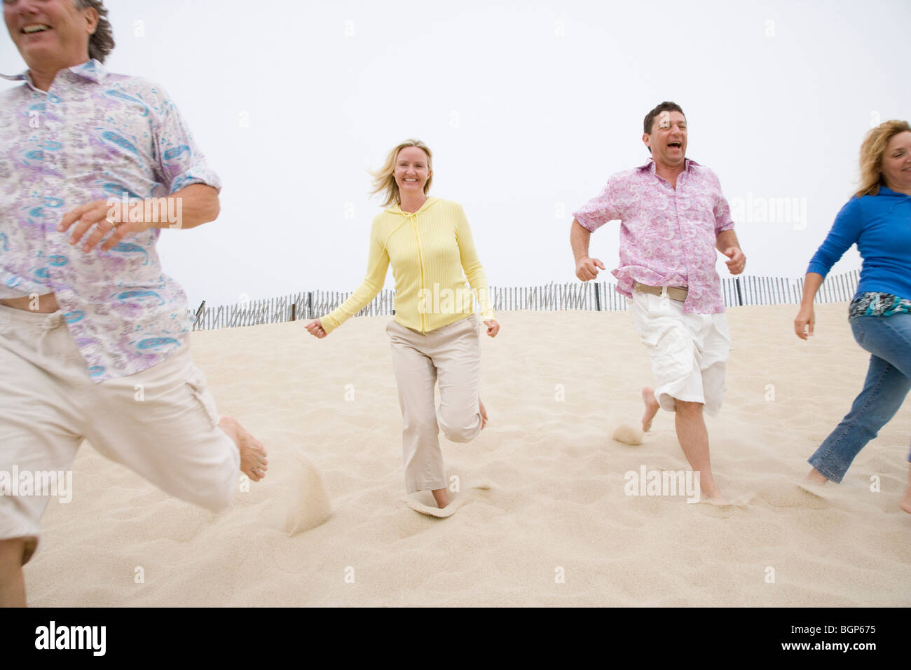 Two couples running on the beach Stock Photo - Alamy