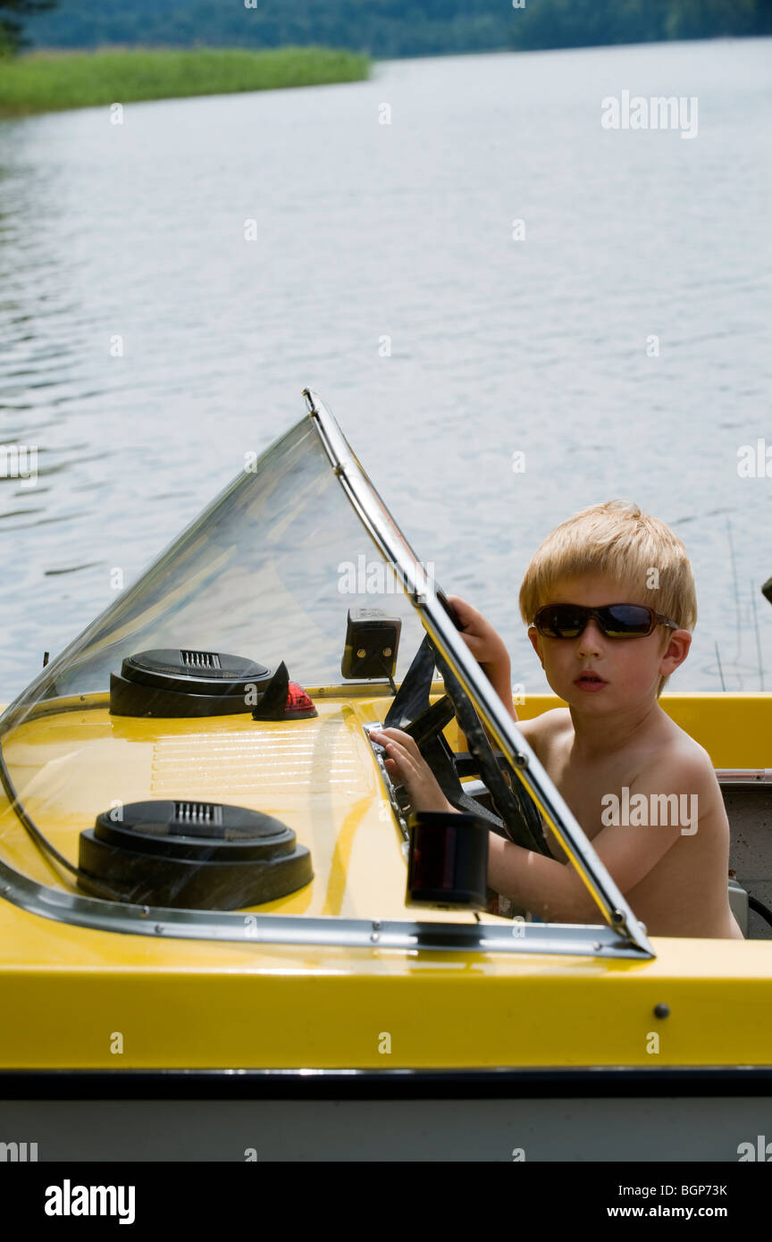 A boy driving a boat, Smaland, Sweden Stock Photo - Alamy