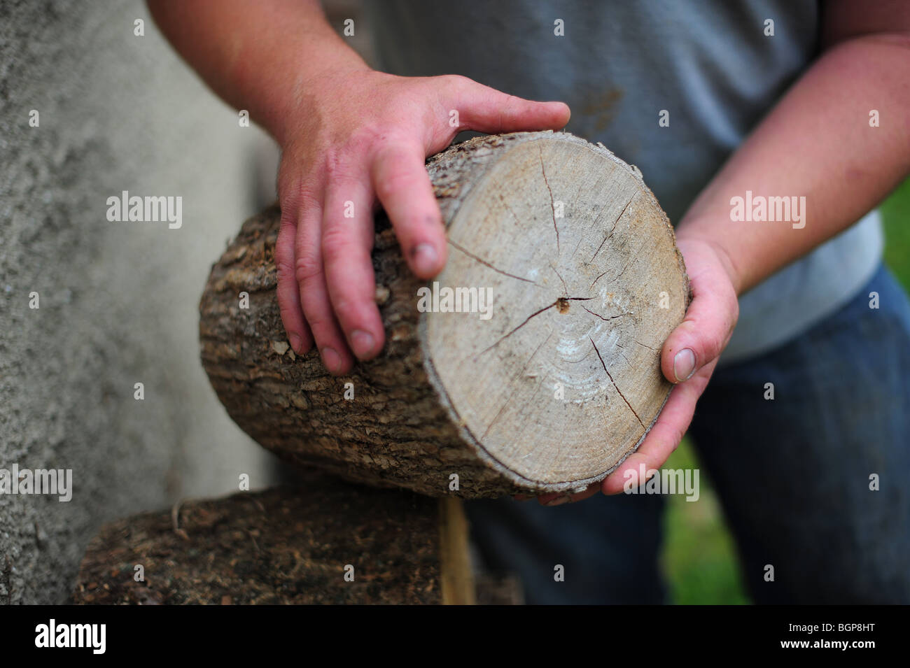 a man holding a wooden log Stock Photo - Alamy