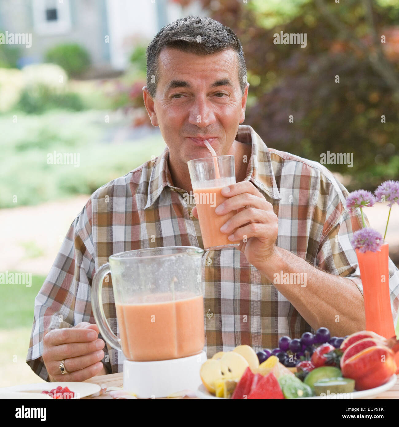 Mature man drinking juice with a drinking straw Stock Photo - Alamy