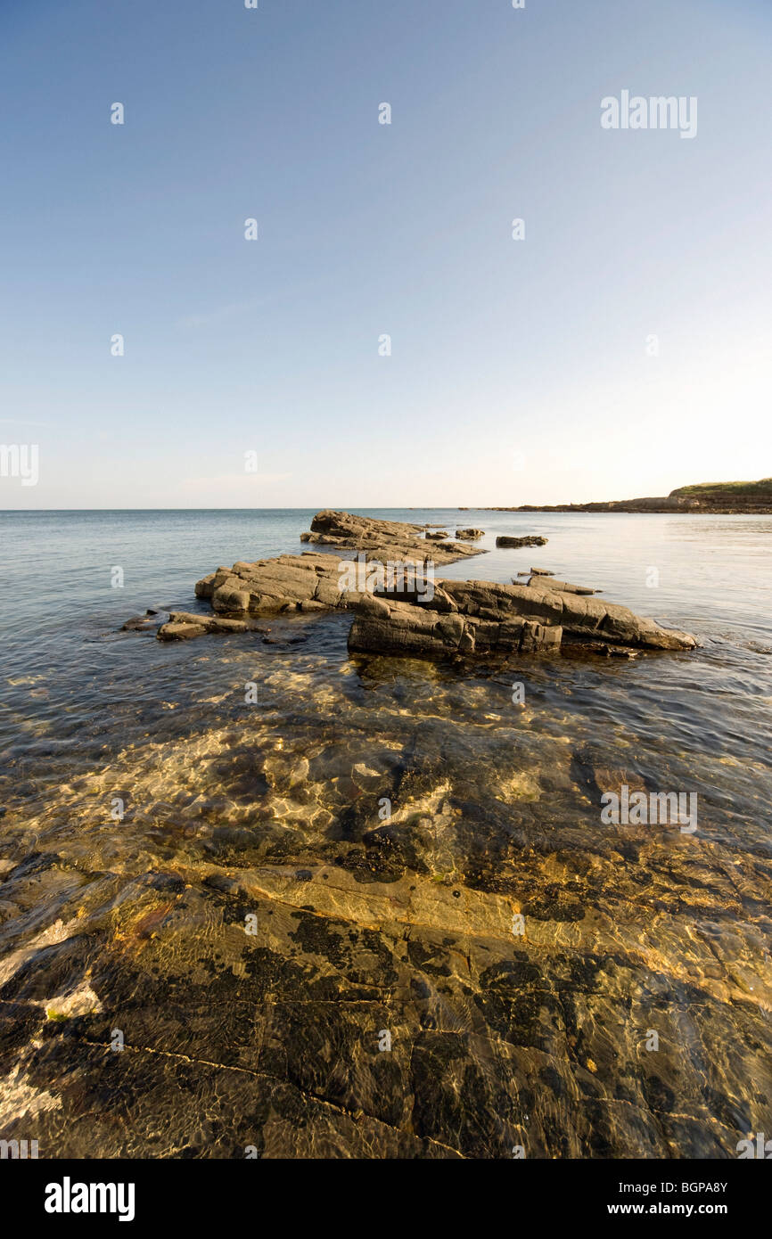 Rocks in shallow water by the shore Stock Photo - Alamy