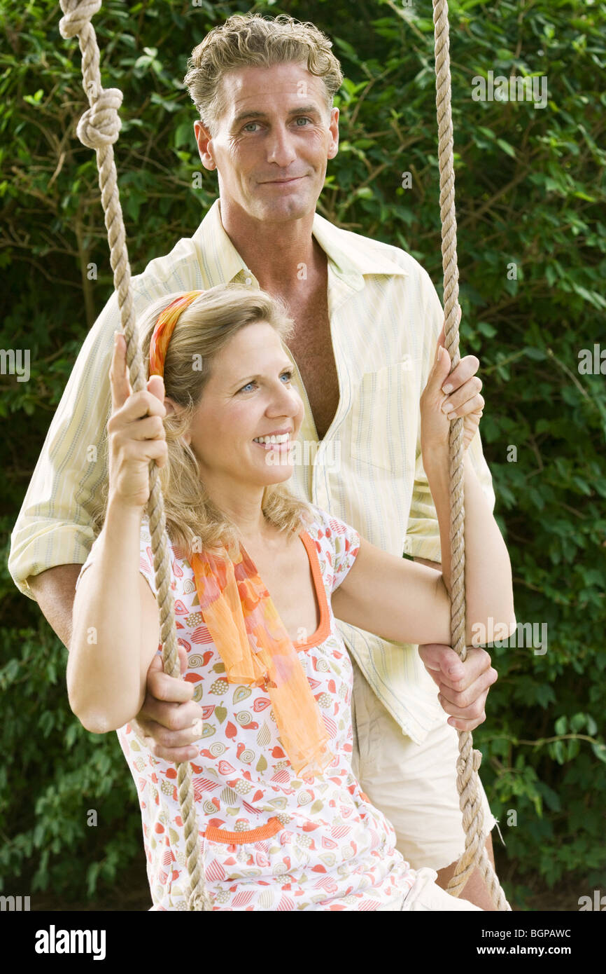 Man pushing a woman on a swing hi-res stock photography and images - Alamy
