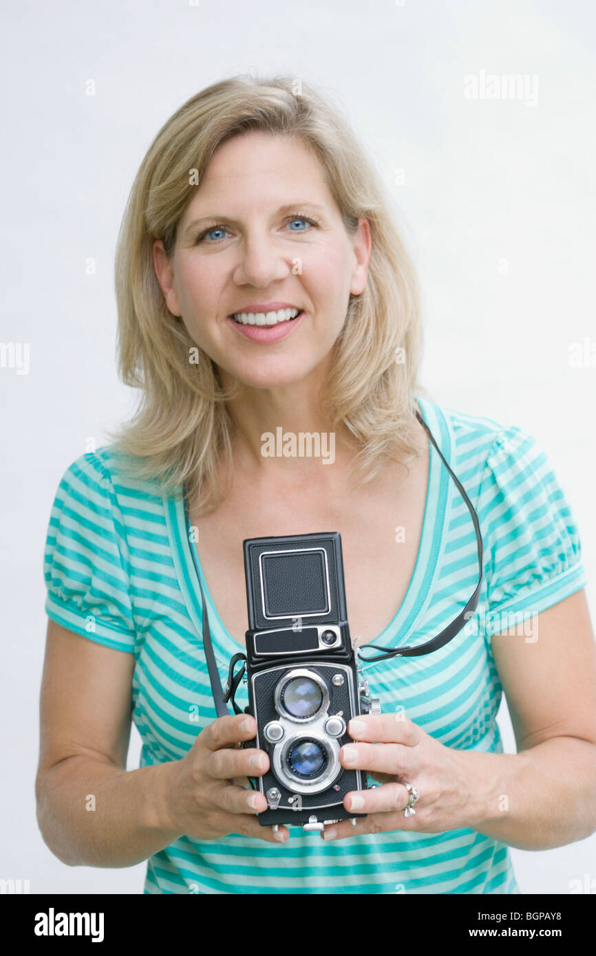 Portrait of a mature woman holding a camera Stock Photo - Alamy