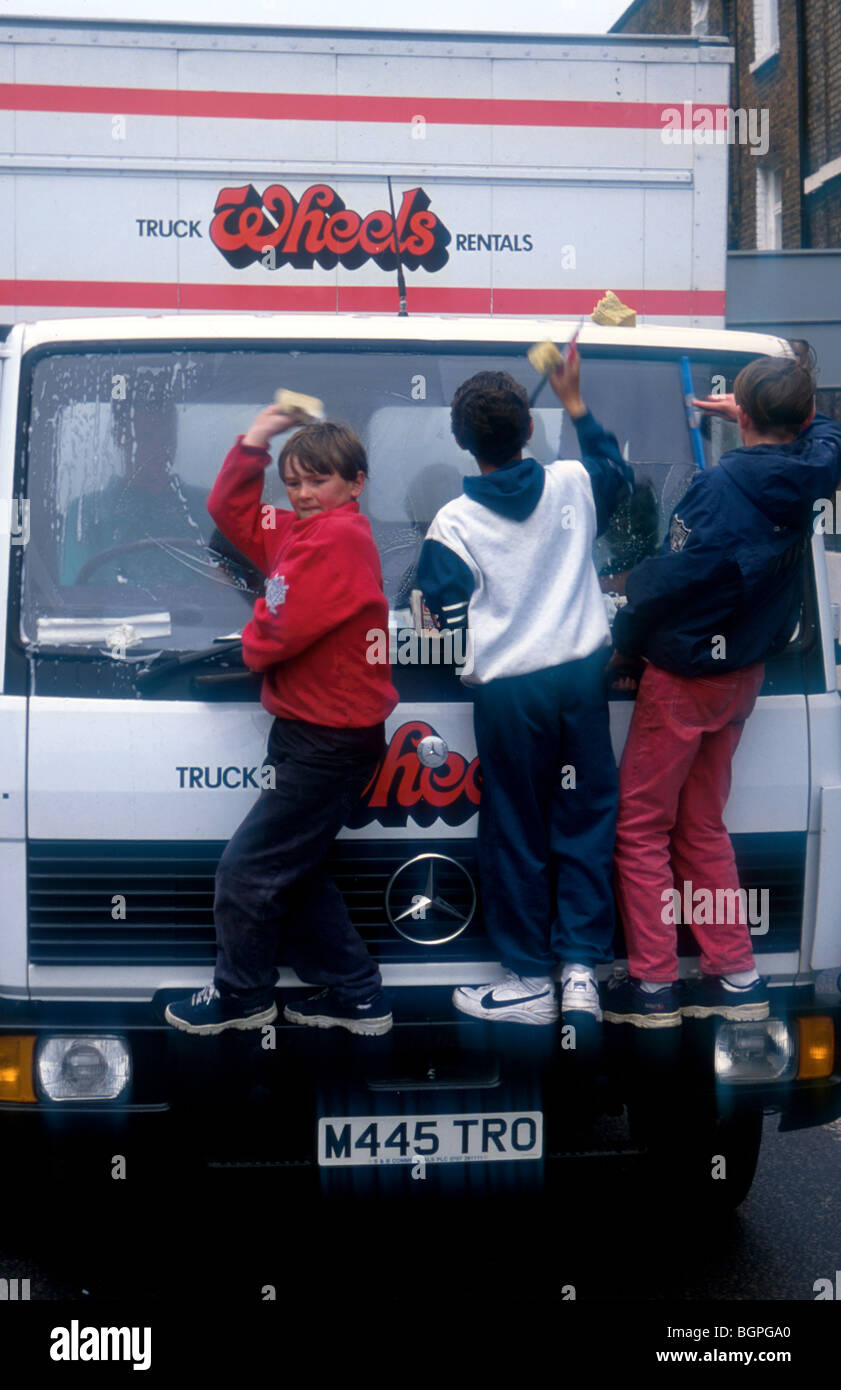 Children washing lorry windscreen at traffic light Camberwell London ...