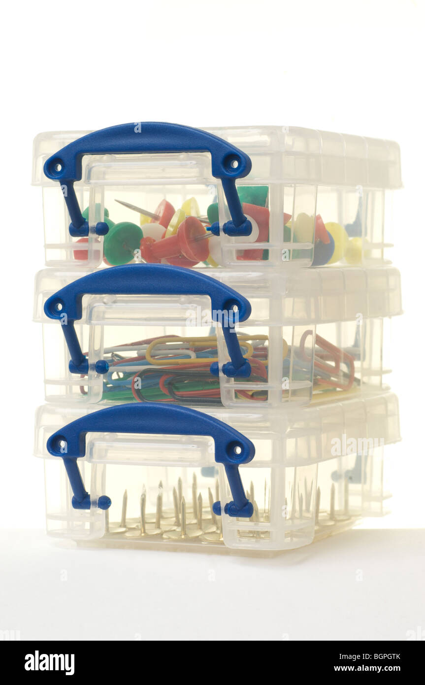 Drawing pins and paper clips in small plastic boxes stacked in threes ...