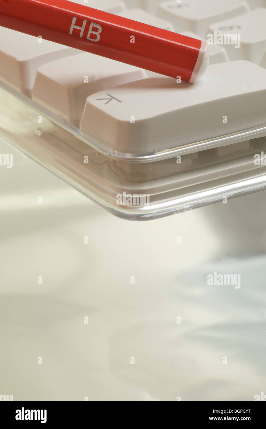 Computer keyboard with red pencil tapping key Stock Photo - Alamy