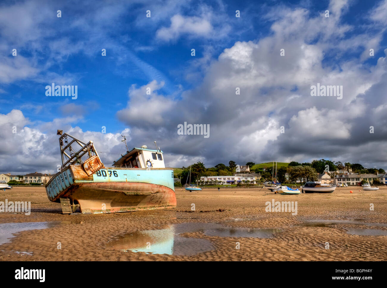 A fishing boat rests on instow beach on a glorious sunny day with vivid ...
