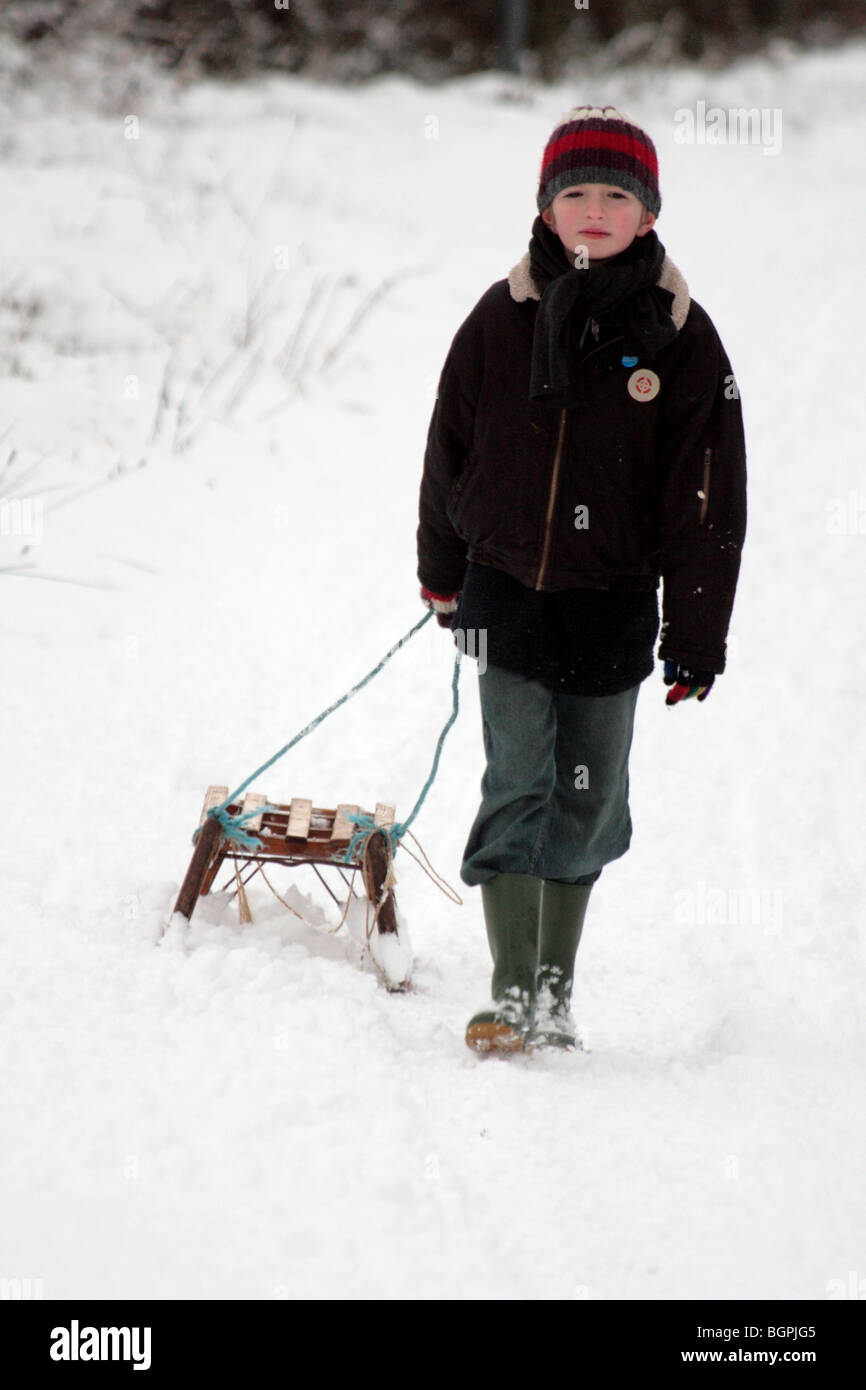 Boy pulling sled in the snow Stock Photo - Alamy