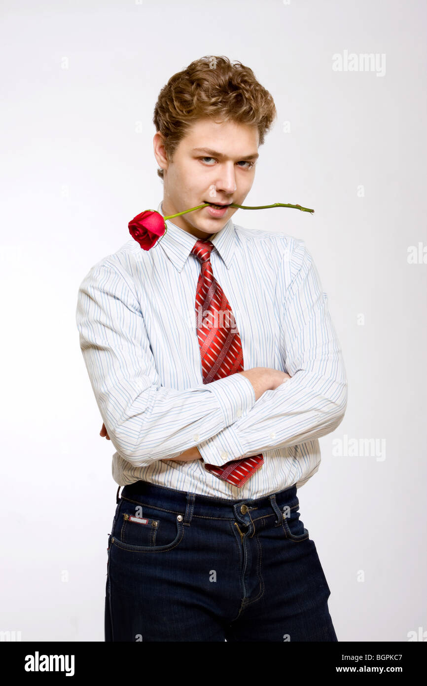 young man with red rose in the teeth Stock Photo - Alamy