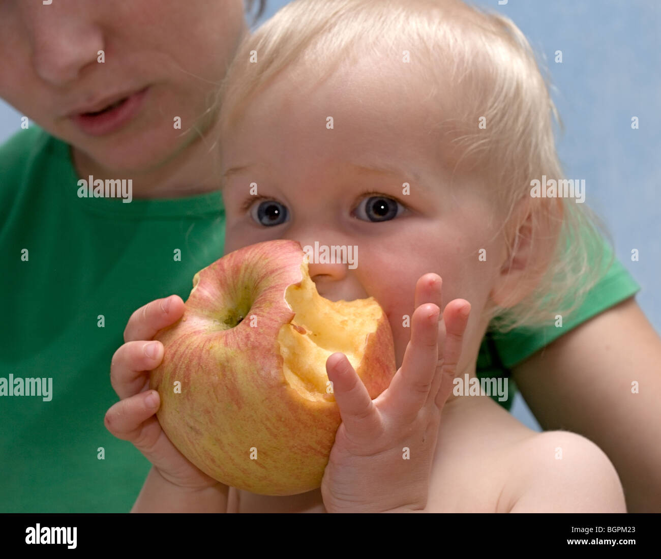 cute baby eats yellow apple. close-up portrait Stock Photo - Alamy