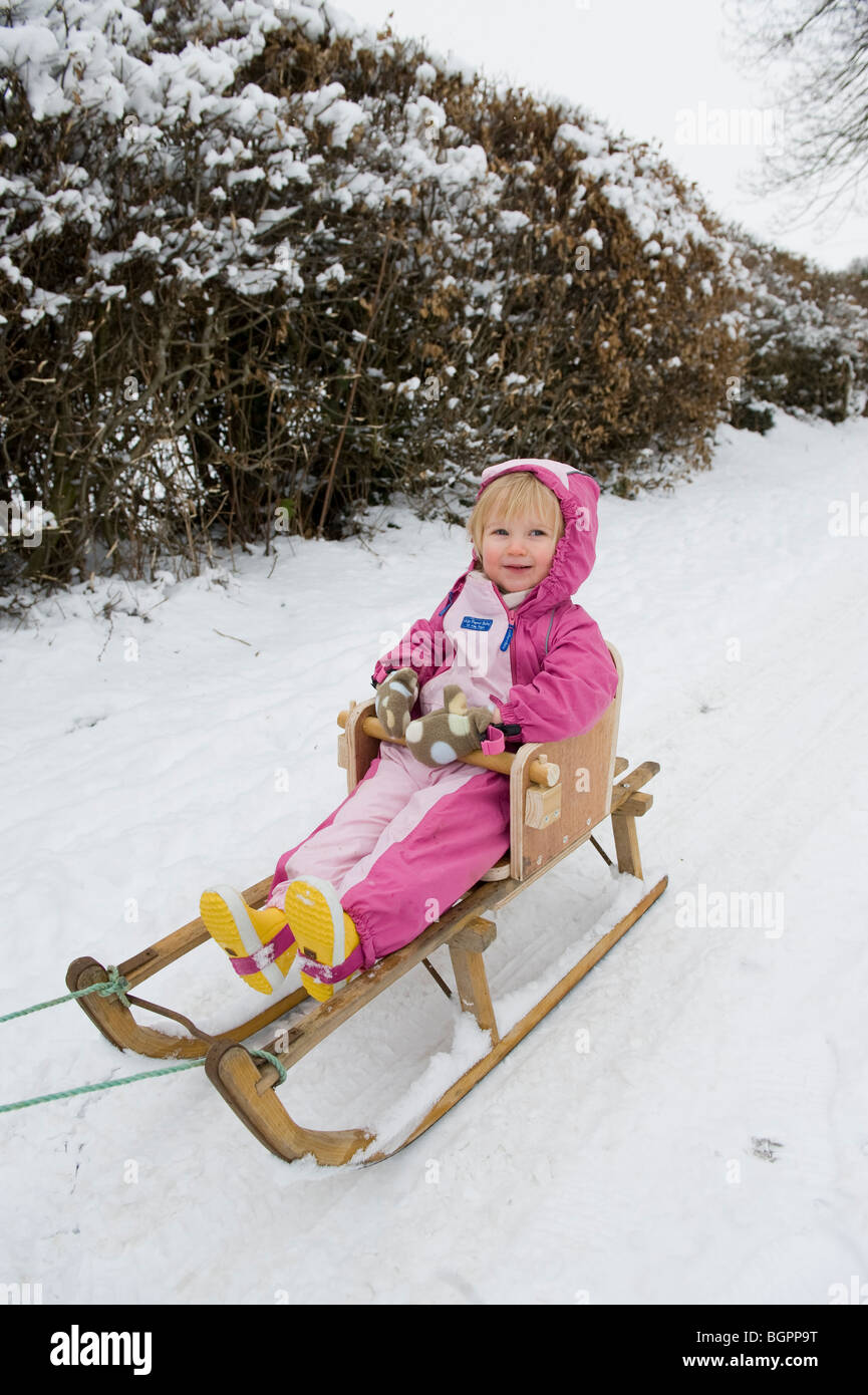 Toddler enjoying the snow on a customized sledge. Transport made easier ...
