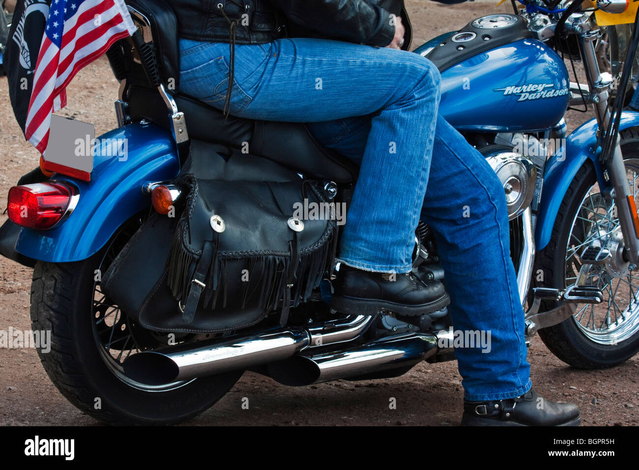 American biker couple sitting on a motorcycle on the road with flag ...