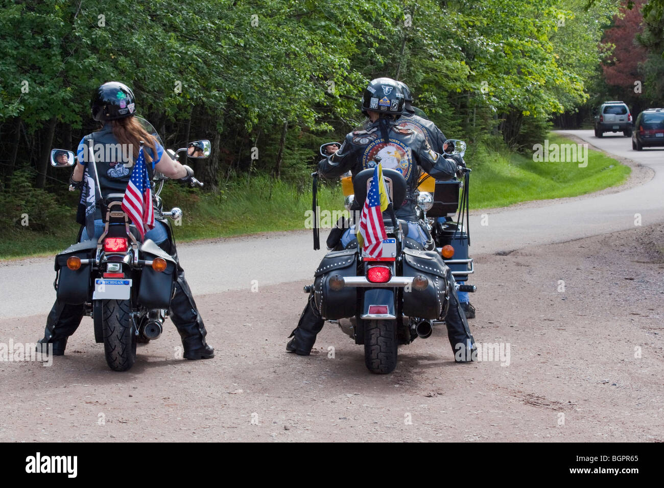 Two bikers on Harley Davidson motorbike from behind view on the road ...