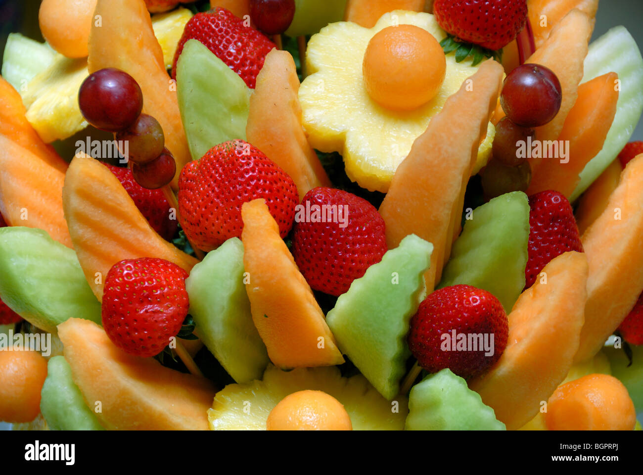 Various fruits in an arrangement, including grapes, pineapple, cantaloupe, honeydew melons and ...