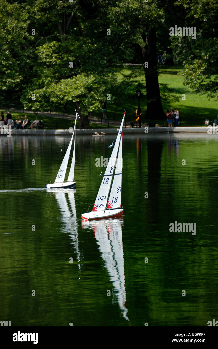 Two model sailboats glide in parallel across the Model Boat Basin in ...