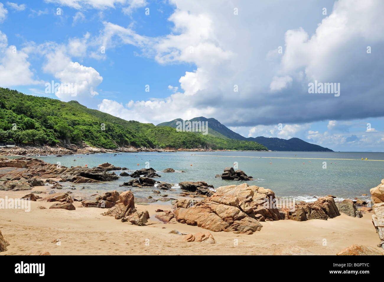 Beach view of sand, rocks, green cliffs and the South China sea, south ...