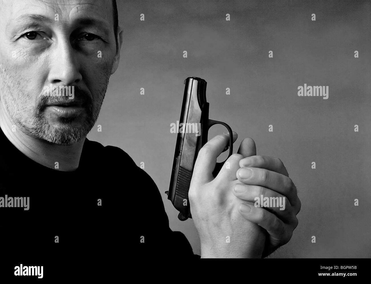 close-up portrait of the man with gun looking at camera, isolated on ...