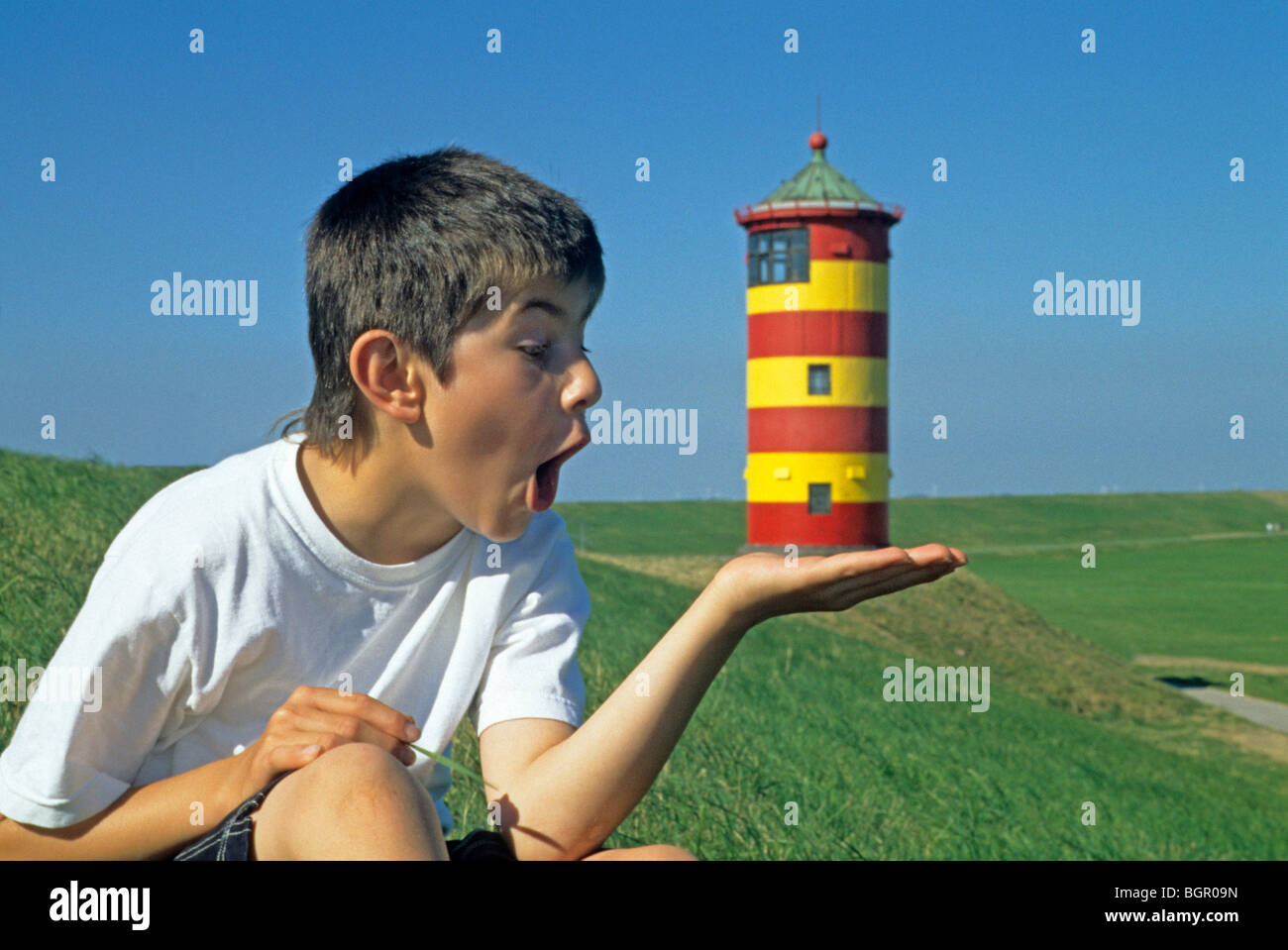 young boy pretending to hold a lighthouse in his hand Stock Photo - Alamy