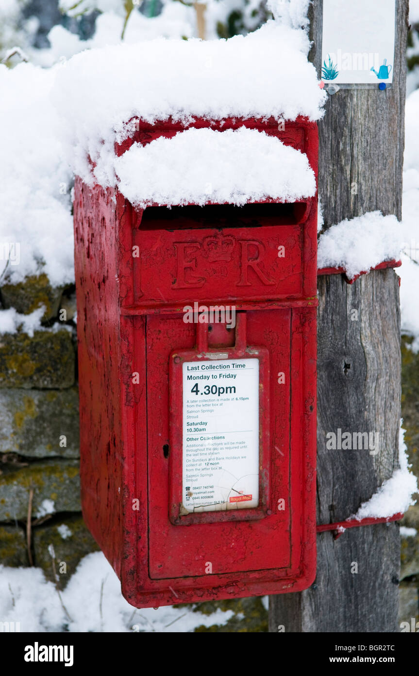 Rusty post box in an English village, covered in snow Stock Photo - Alamy