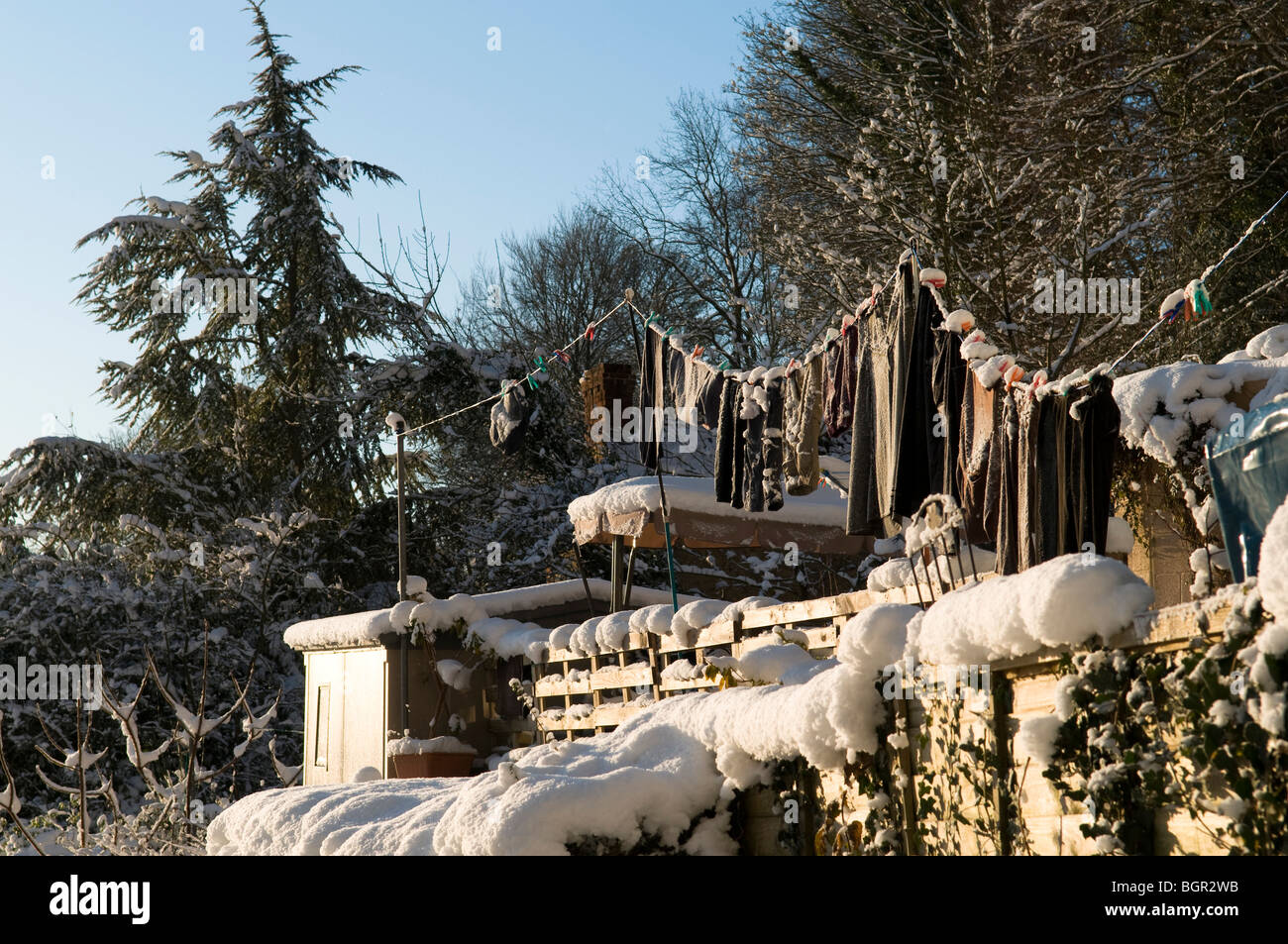 Snow-covered clothing hung out to dry on a clothes line Stock Photo - Alamy