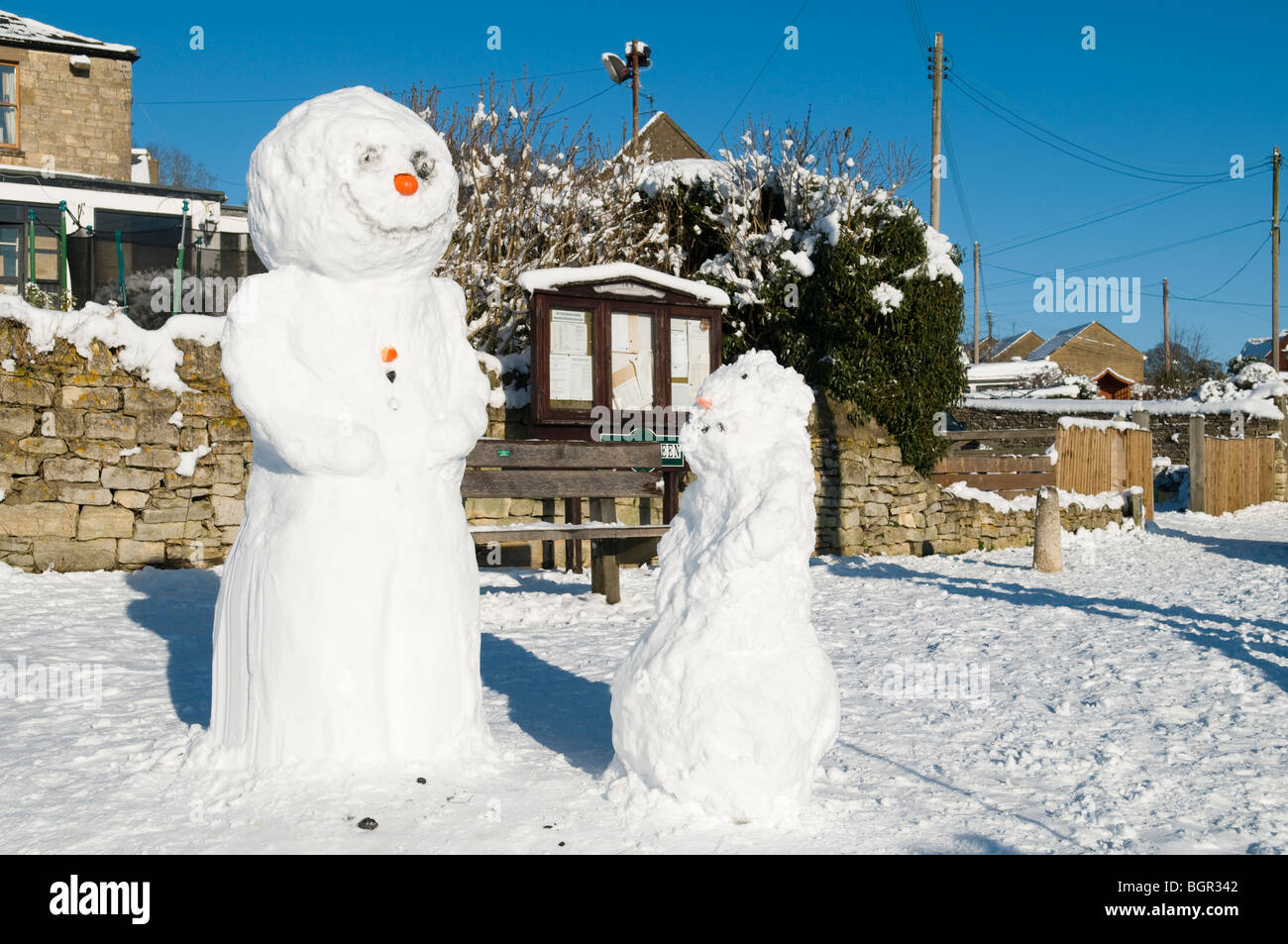 Pair of snowmen on the Whiteshill Village Green in The Cotswolds Stock ...