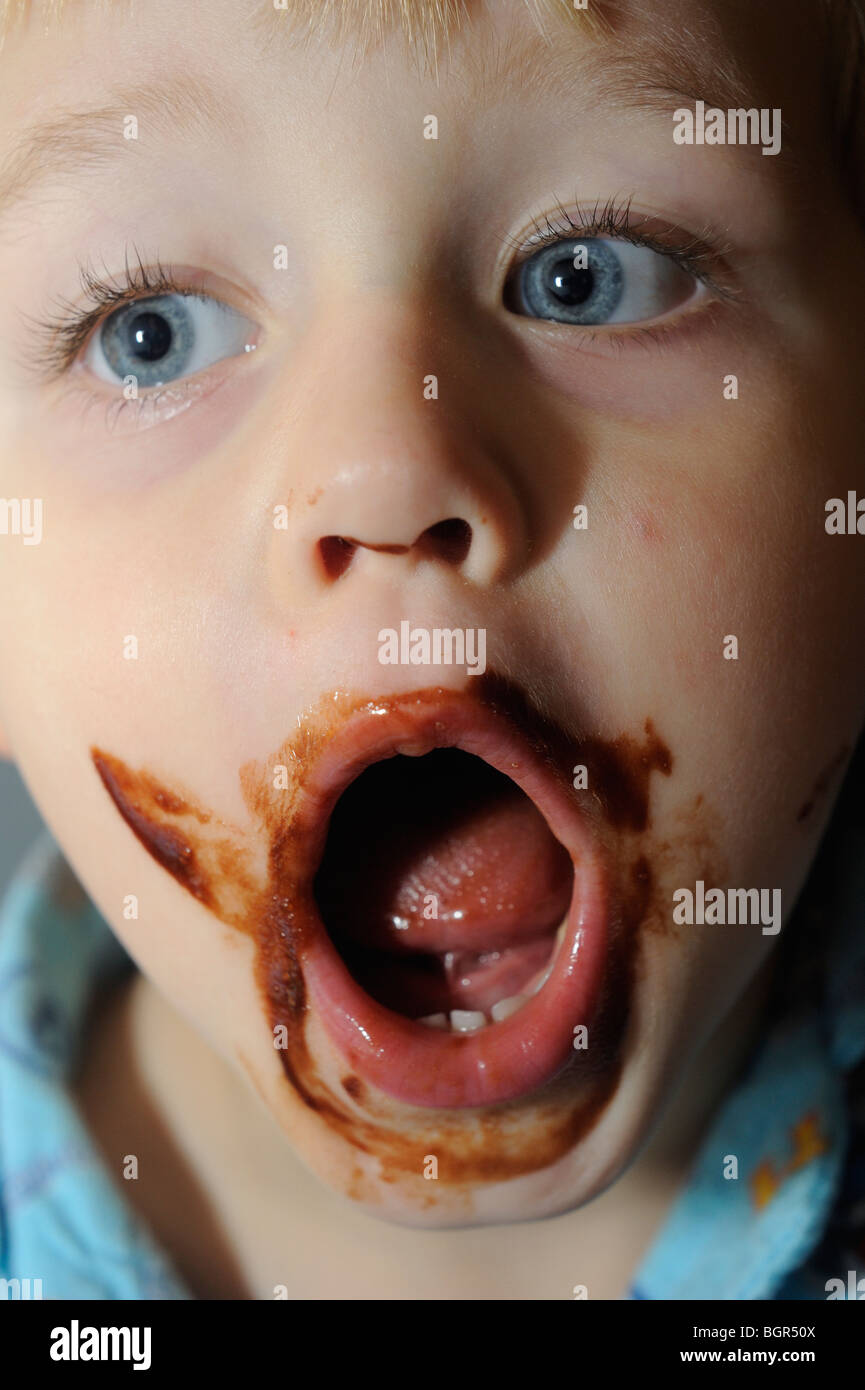 young child blond boy with chocolate smeared all over face Stock Photo ...