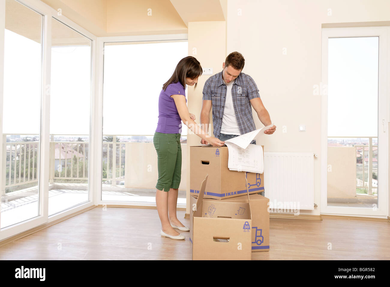 man and woman in an empty house with boxes near making plans on how to ...