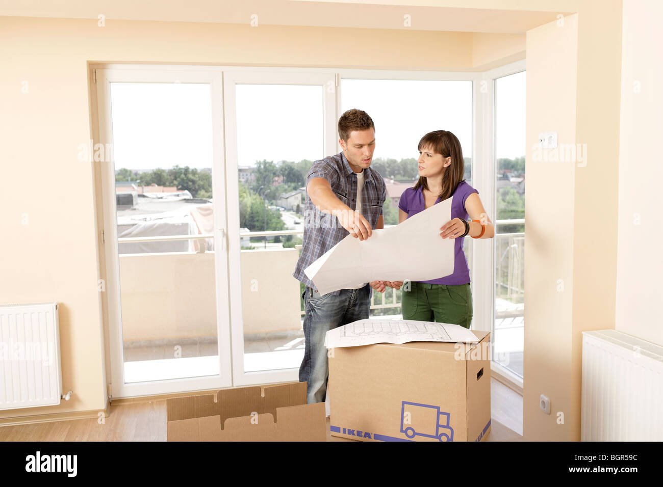 man and woman in an empty house with boxes near making plans on how to ...