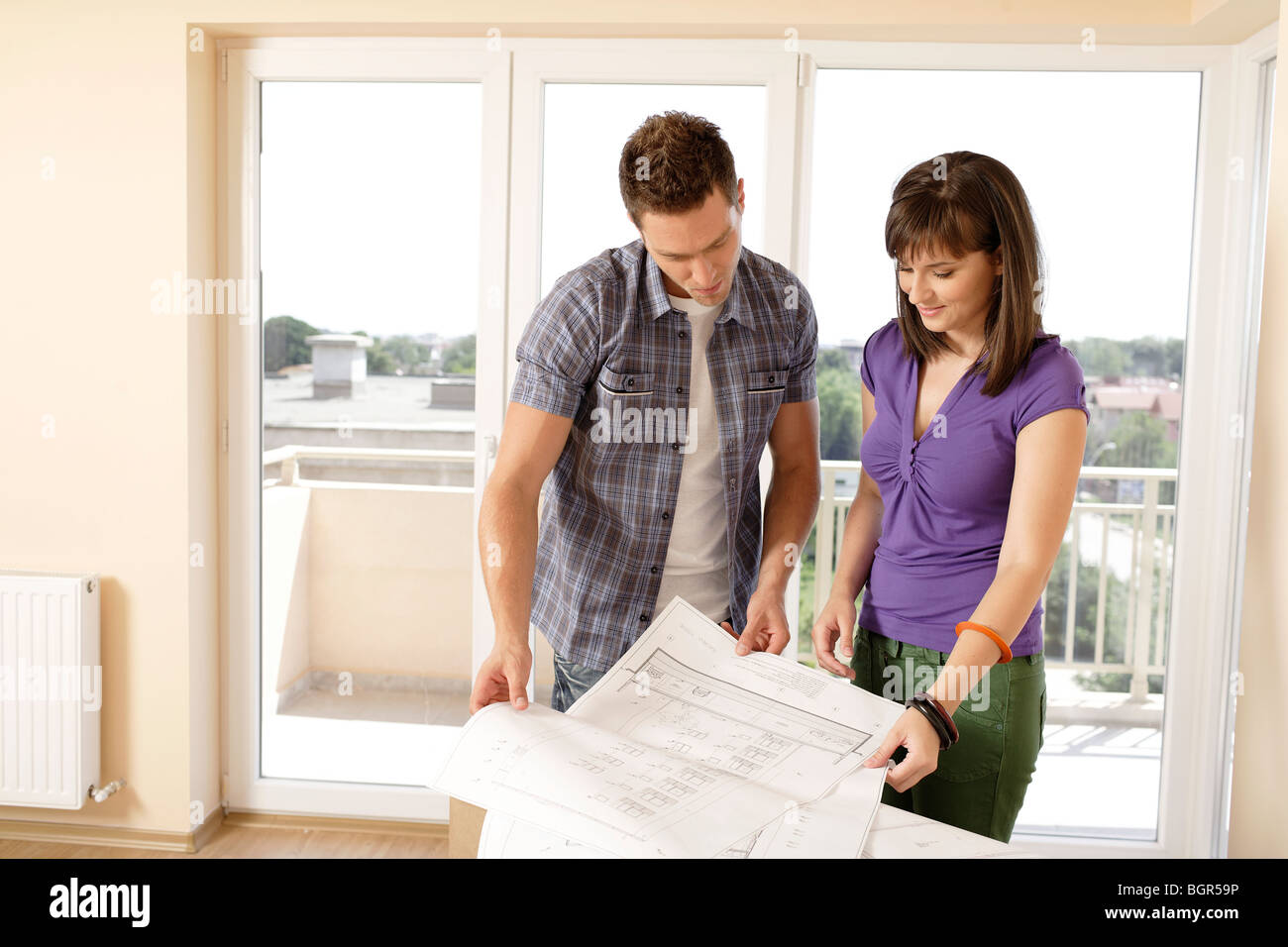 man and woman in an empty house with boxes near making plans on how to ...