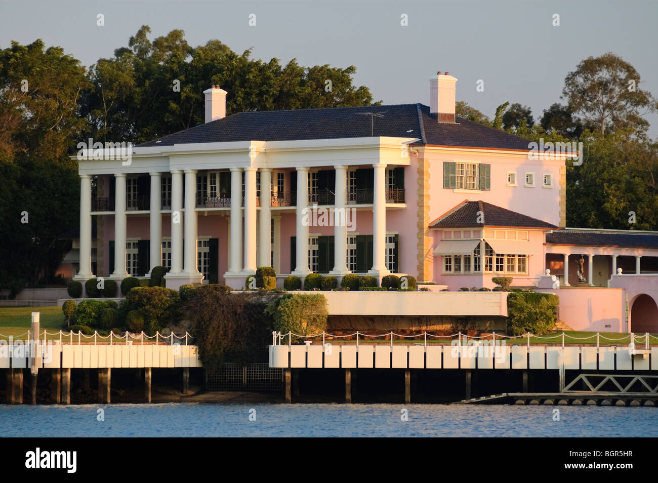 Very large pink mansion house glowing in the evening sun Stock Photo ...