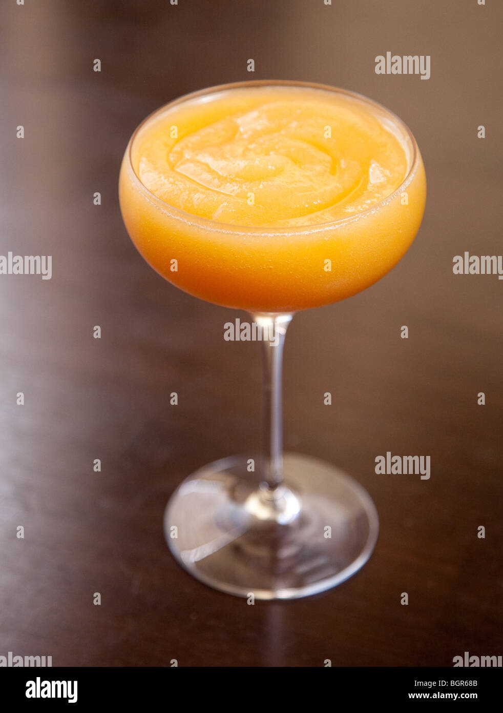 An orange colored cocktail in a tall stem glass Stock Photo - Alamy