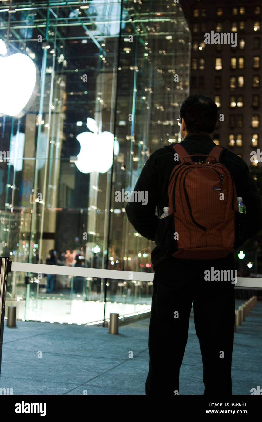 A man stands in front of the 5th Avenue Apple Store in New York City ...