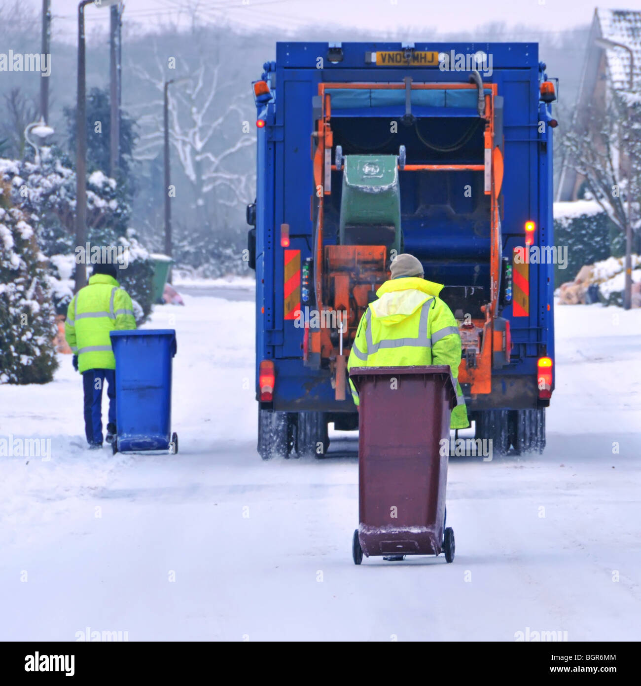 Dustcart lorry and binmen on icy snow covered residential road Stock ...