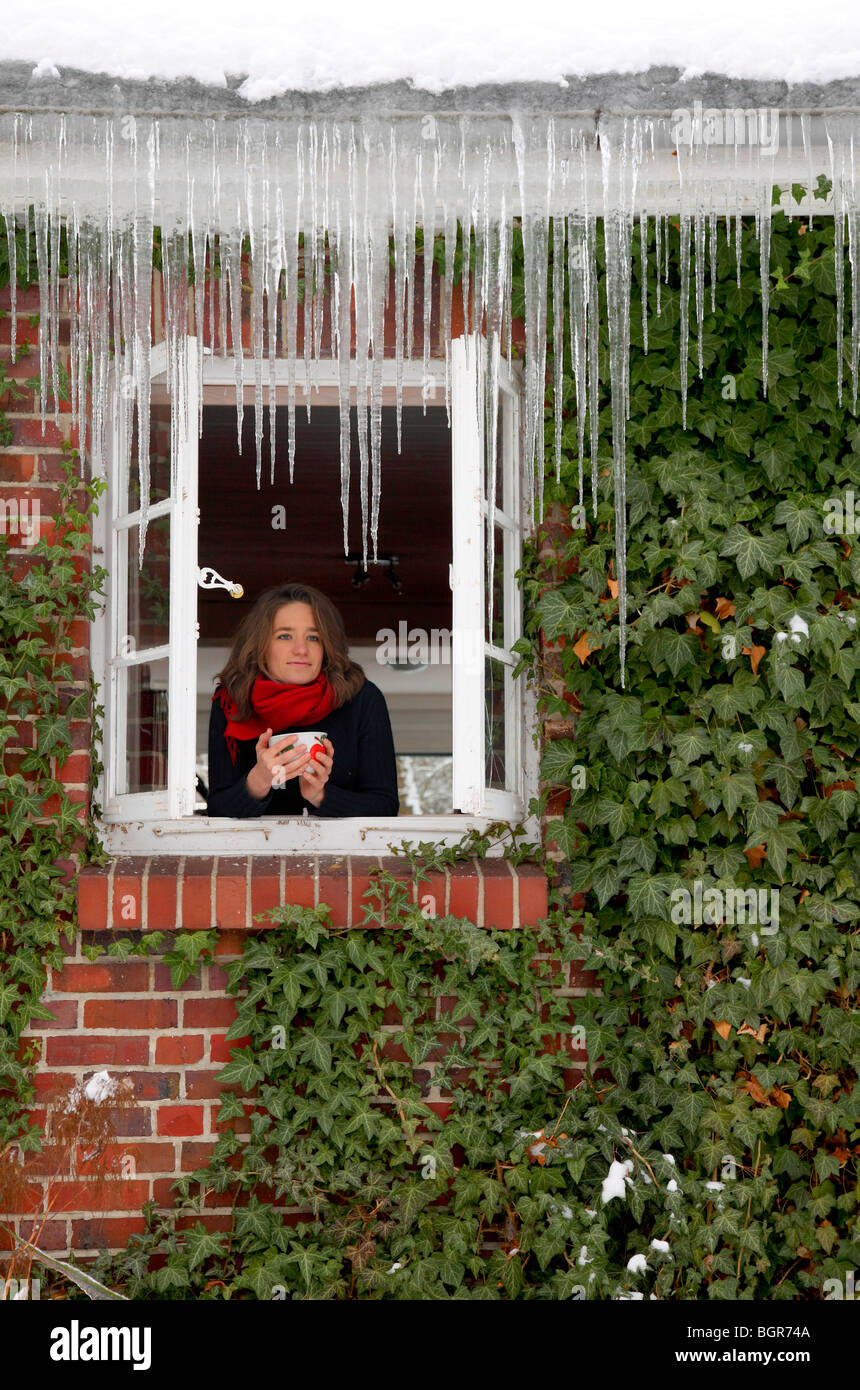Young woman looking out of the window in the winter Stock Photo - Alamy